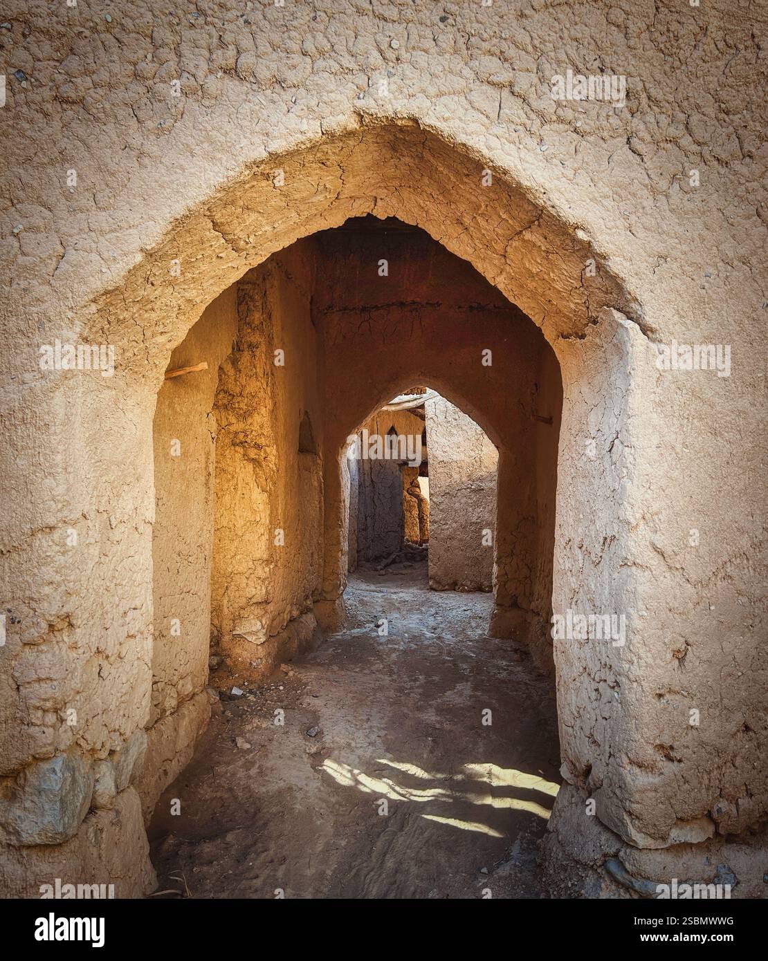 A historic mud-brick alley in Adam Fort, Oman, capturing the essence of ...