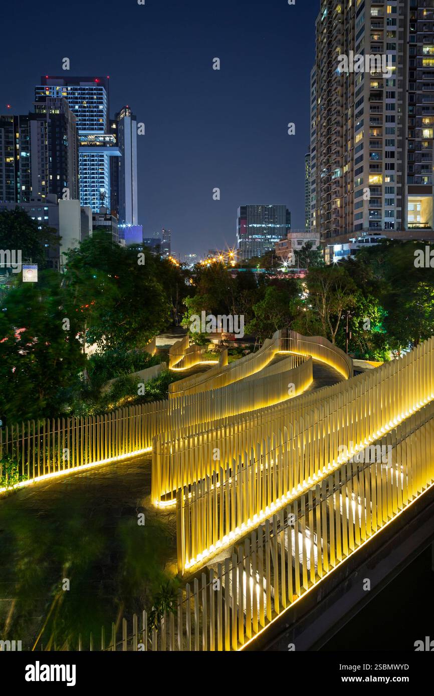View of the empty and illuminated Chong Nonsi Canal Park and tall ...