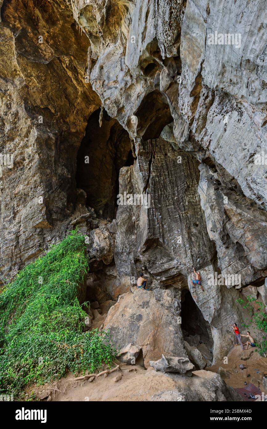 Few rock climbers in a stunning, high, big and steep cave at the ...