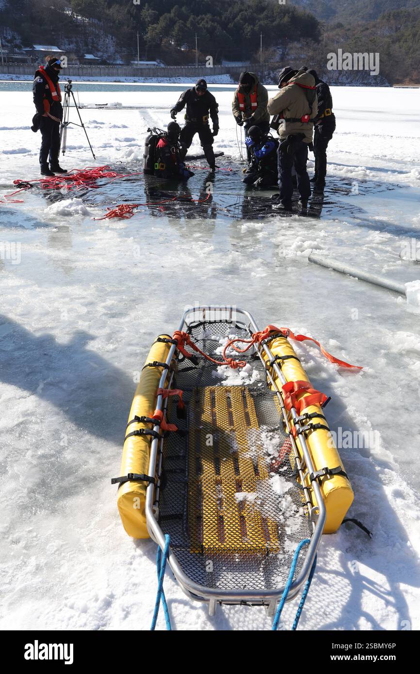 Wintertime disaster response drill in reservoir Rescuers enter a hole ...