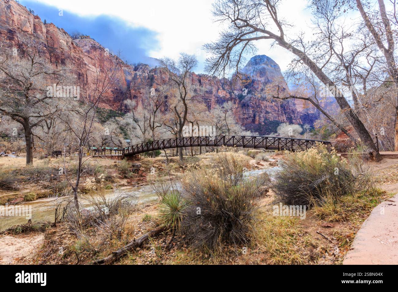 Bridge over a river in a desert. The bridge is wooden and spans the ...