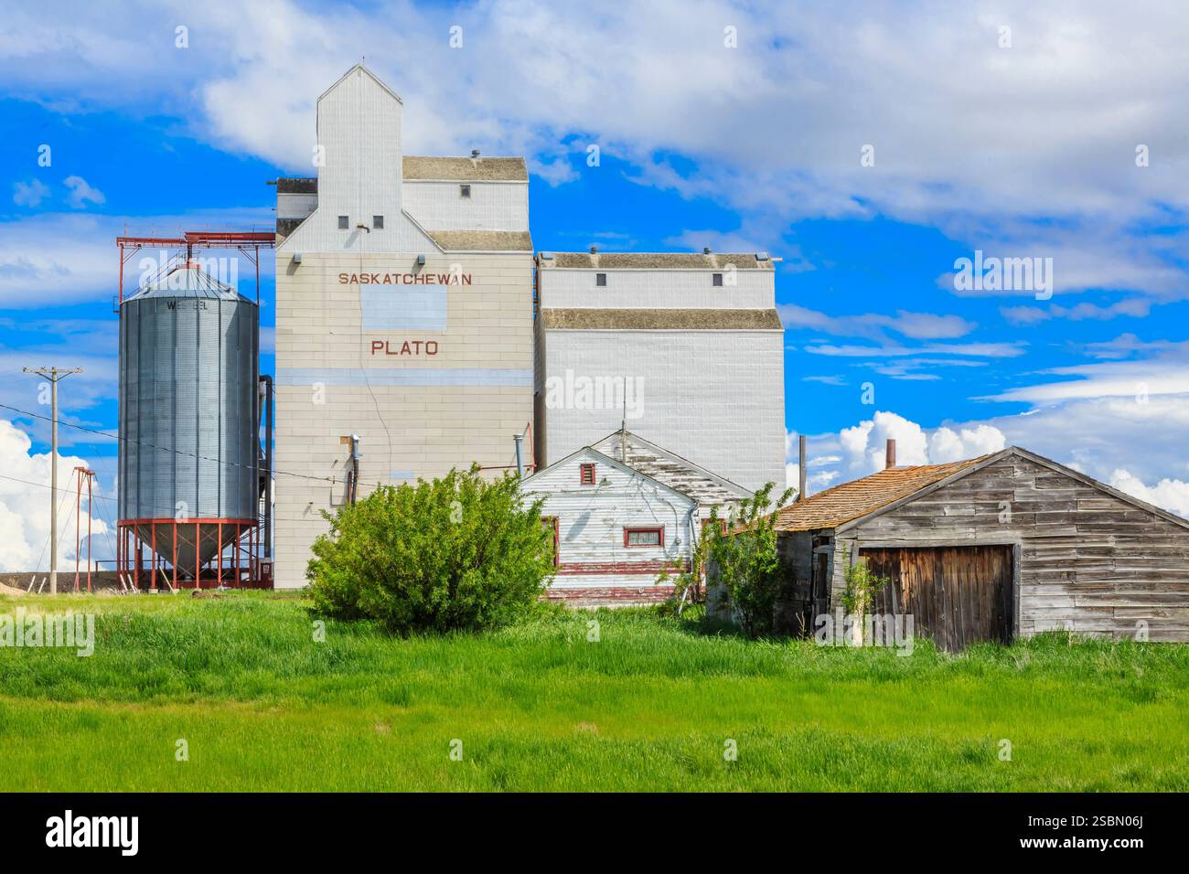 Large grain silo with the letters PLATC on it. A small house is next to ...