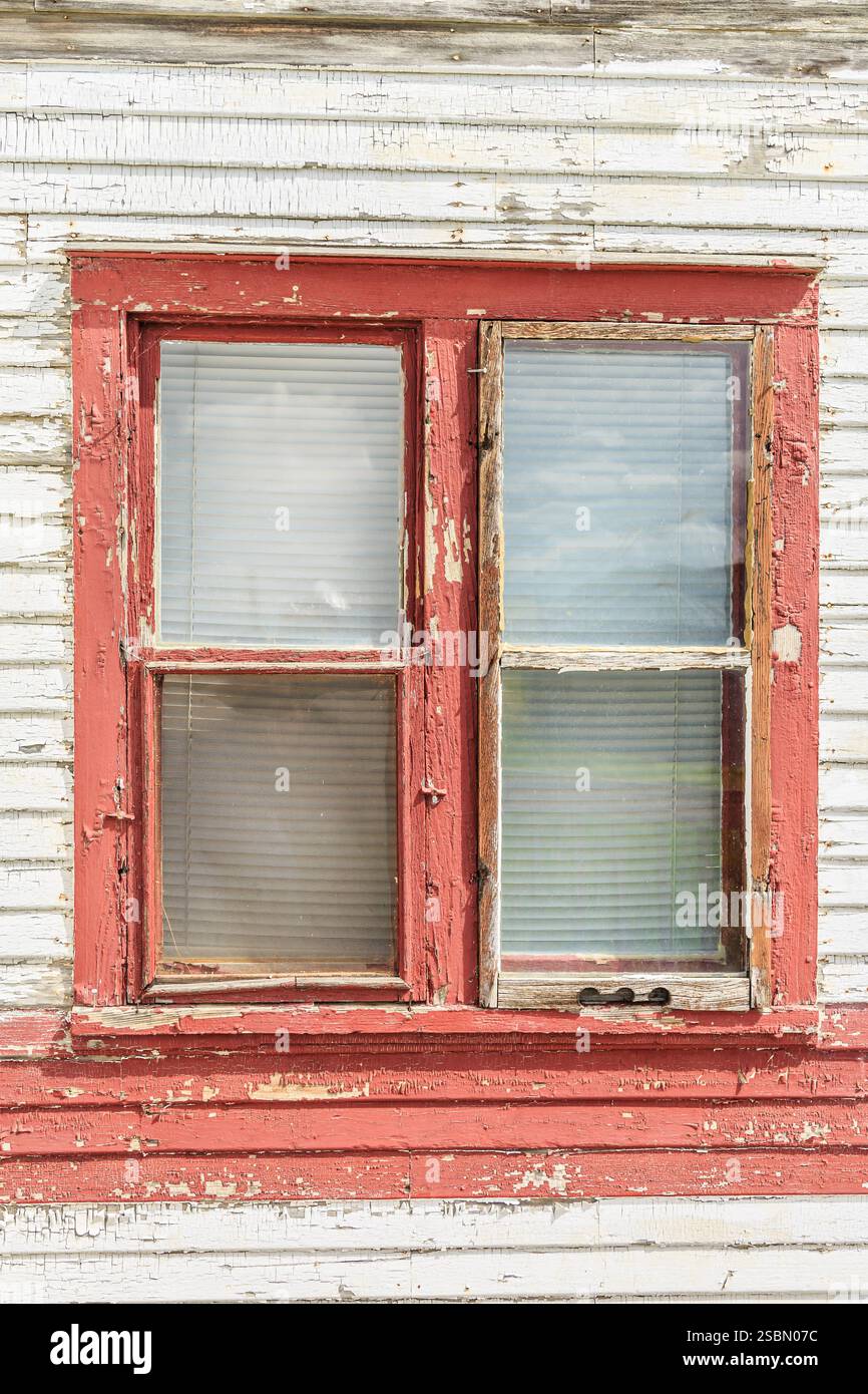 Window with a red frame and white blinds. The blinds are open. The ...
