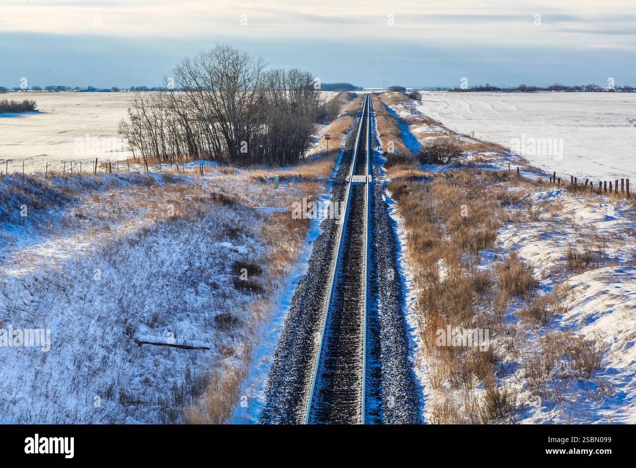 Train track is shown in the snow. The tracks are empty. The snow is ...