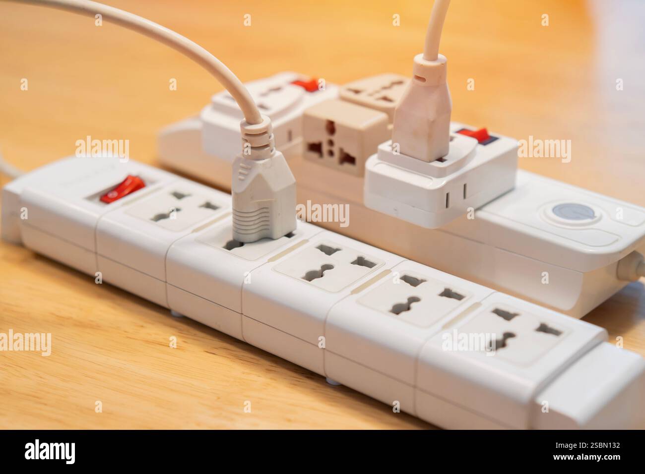 Many electrical plugs connected to a power white strip or extension ...