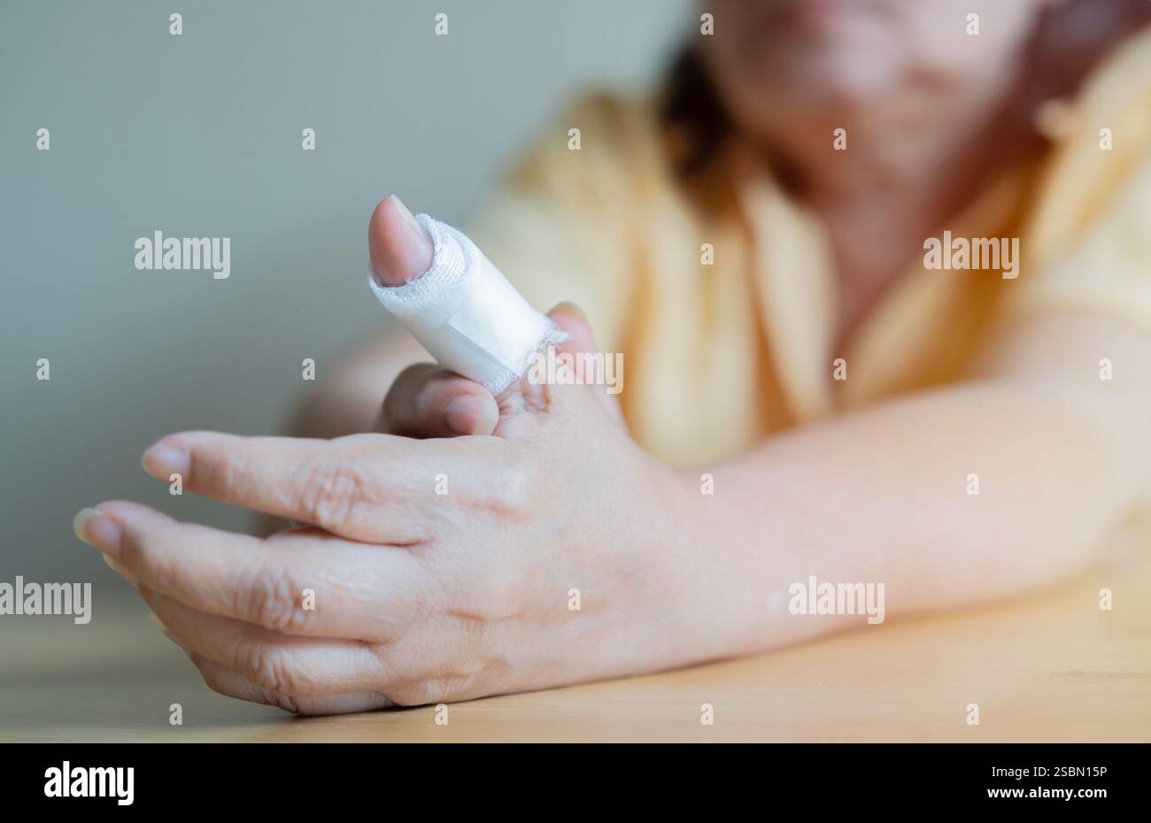 Old woman Injured painful finger with white gauze bandage. Selective ...