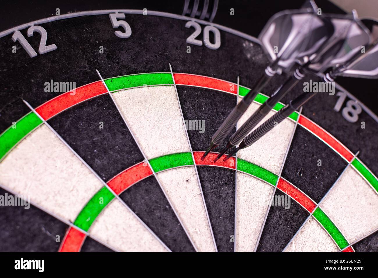 Official dartboard with three darts sticking in the triple twenty (180 ...