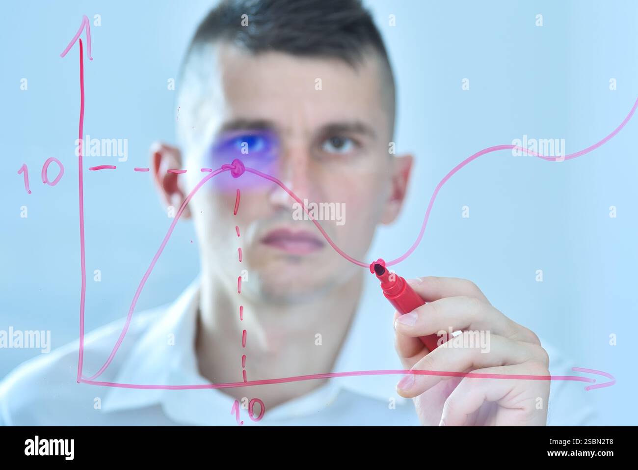 Businessman with red pen drawing stock chart on glass screen. Analyzing ...