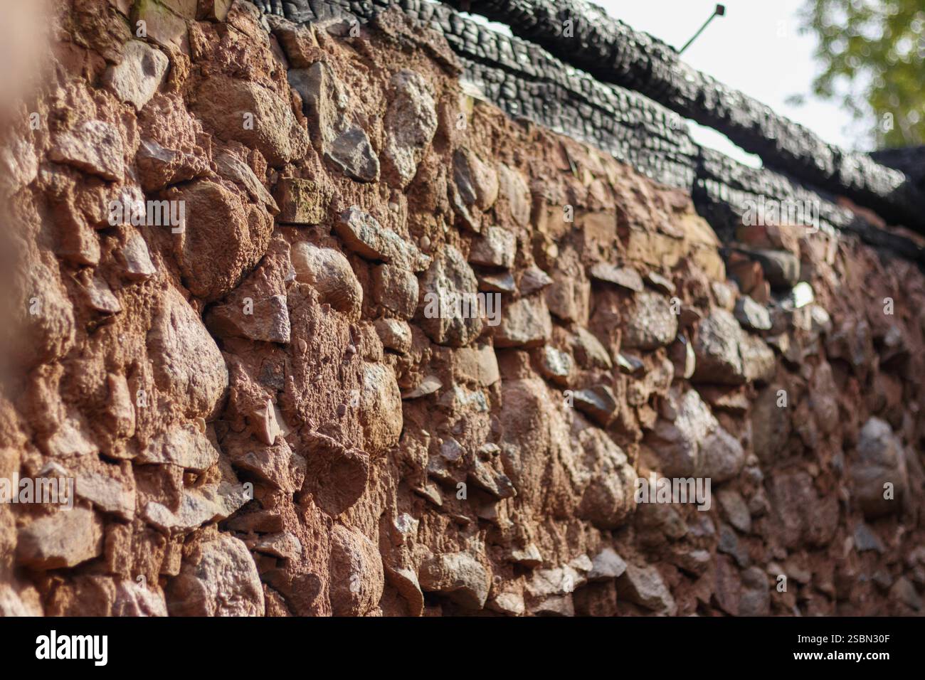 a stone wall made of stones of various sizes and colored in a reddish ...