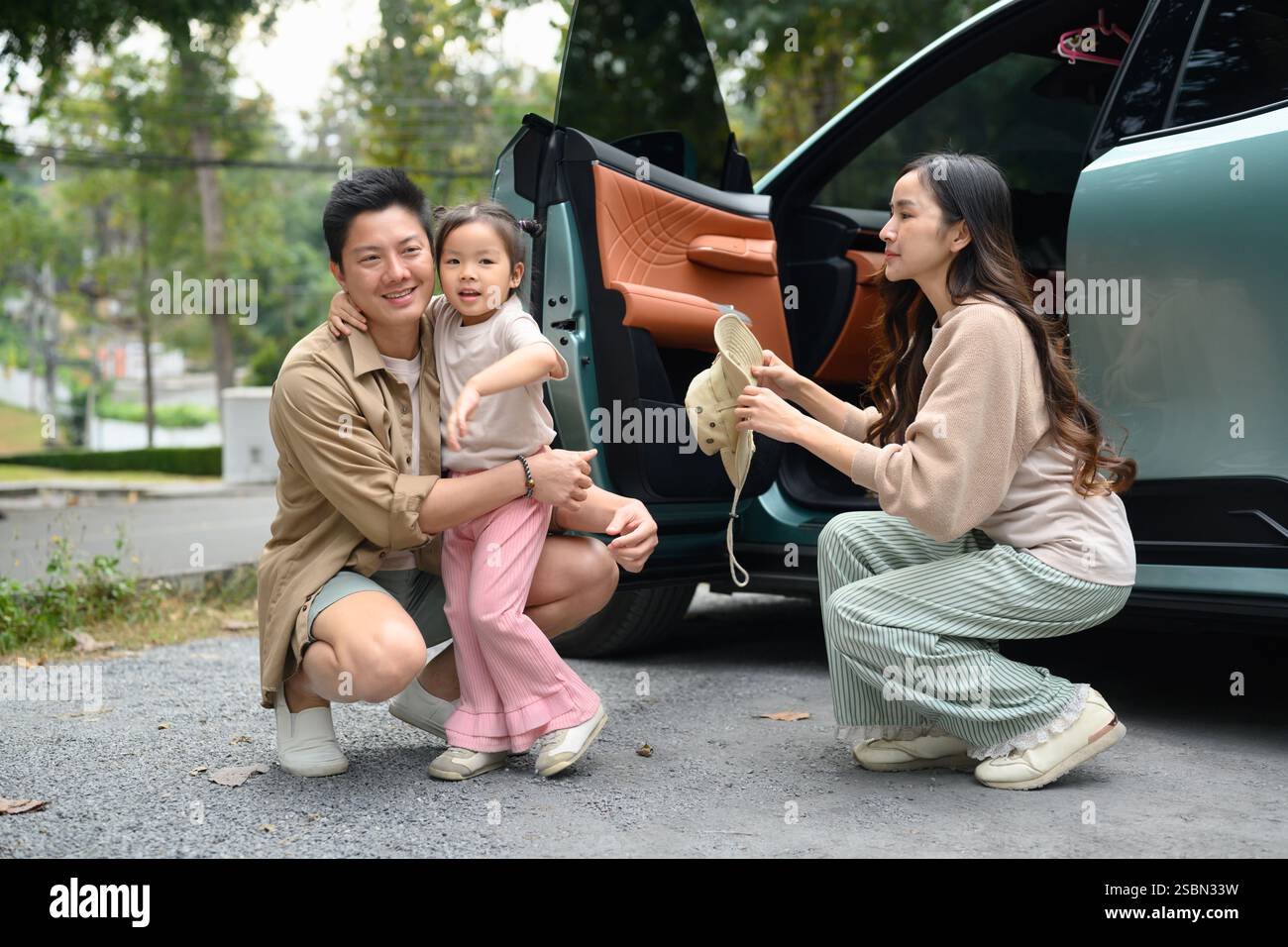 Loving parents dressing their child for an outdoor adventure. Holiday ...