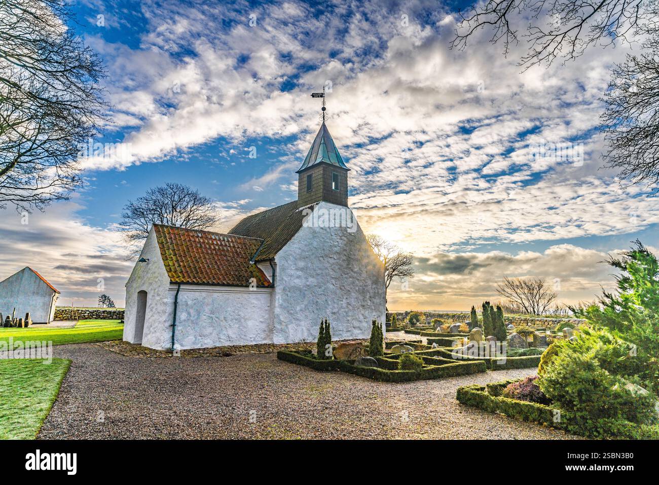 A rustic church set in a tranquil cemetery with vibrant greenery, under ...