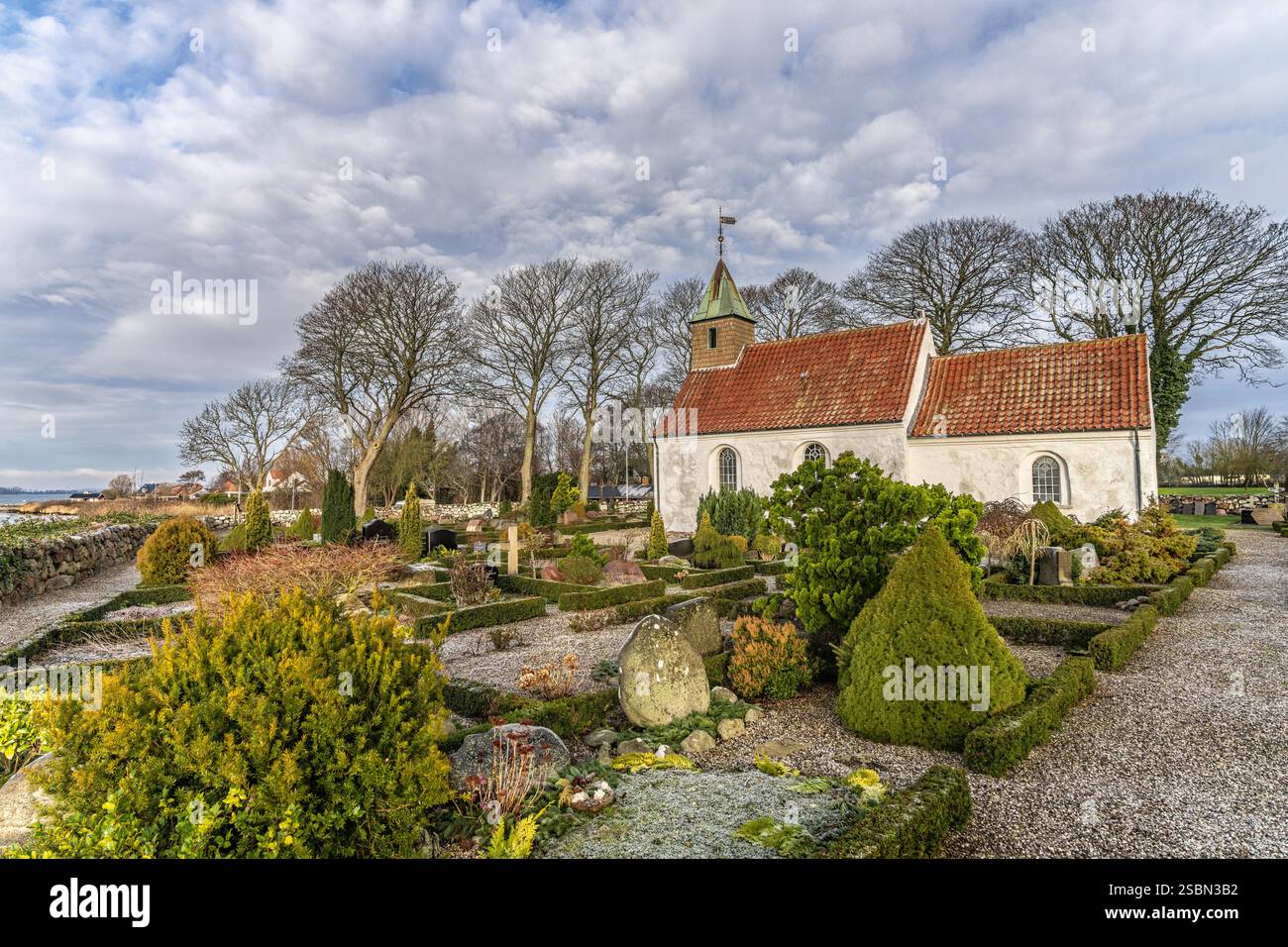 A rustic church set in a tranquil cemetery with vibrant greenery, under ...