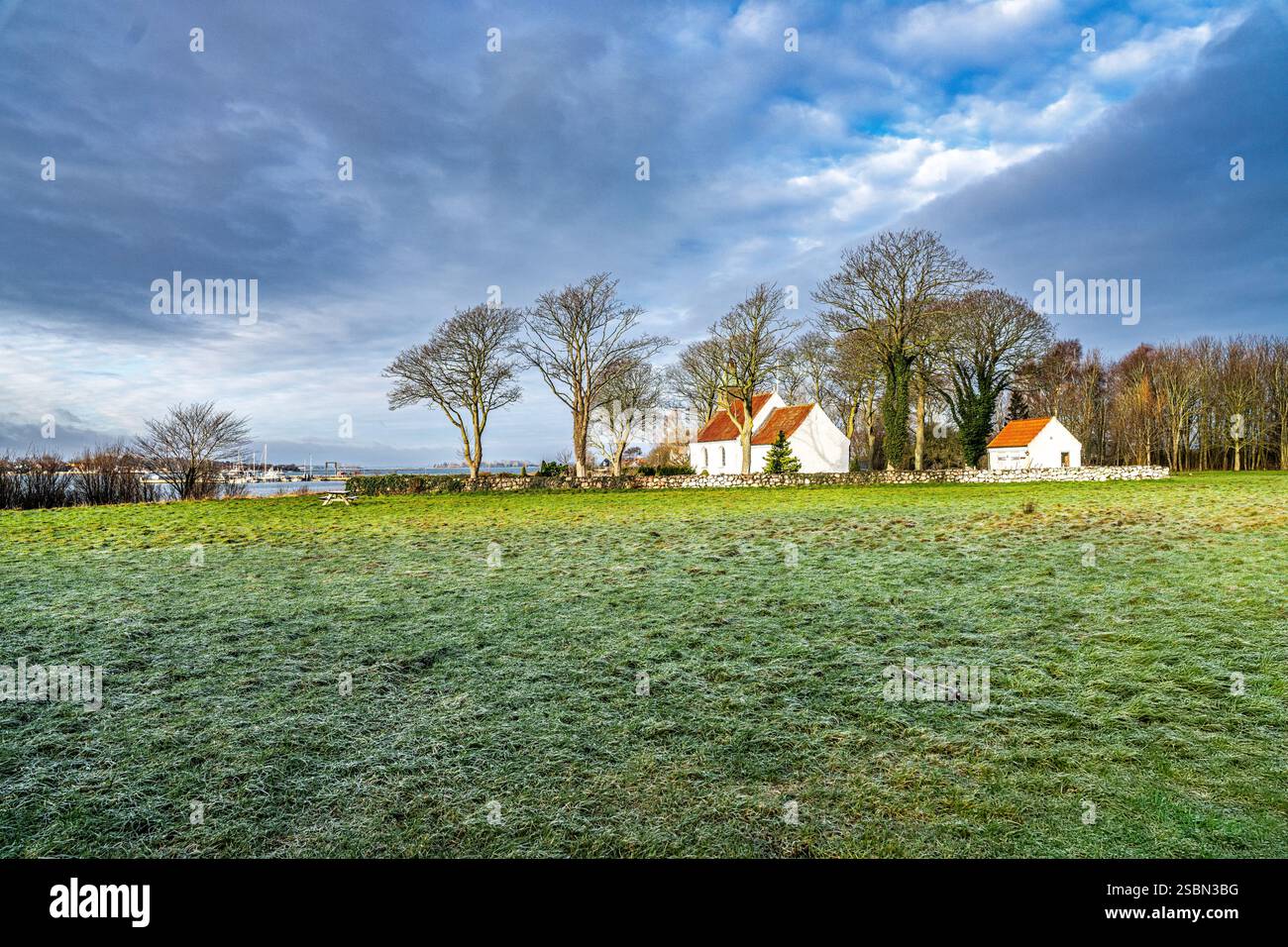 A rustic church set in a tranquil cemetery with vibrant greenery, under ...