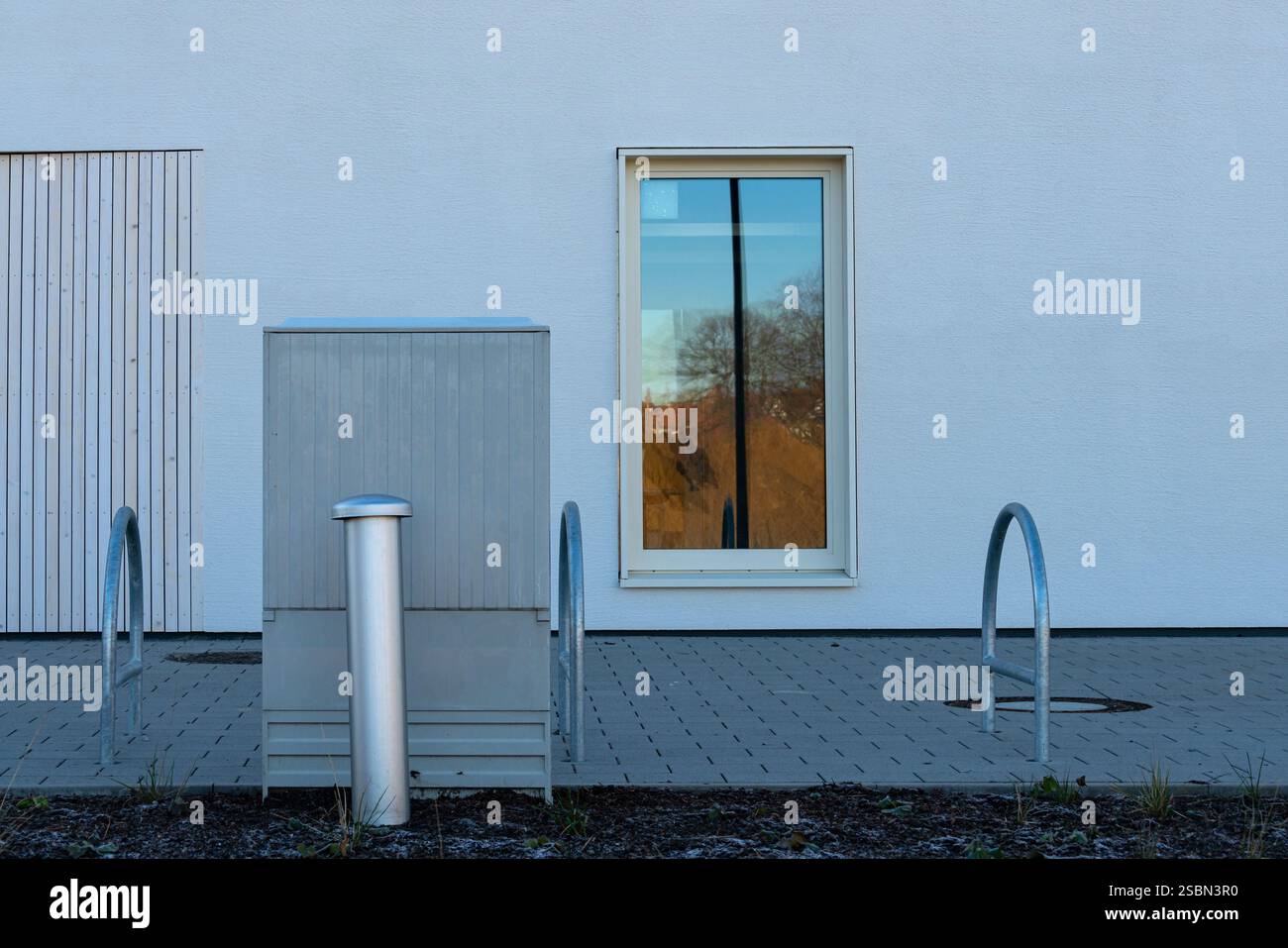 A clean and simple building exterior featuring a reflective window ...