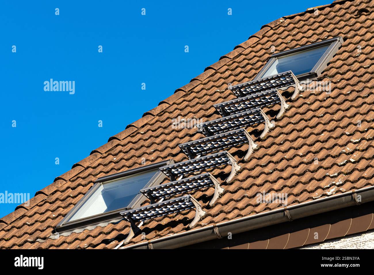 Metal stairs are arranged neatly on a sloped roof, positioned beside ...