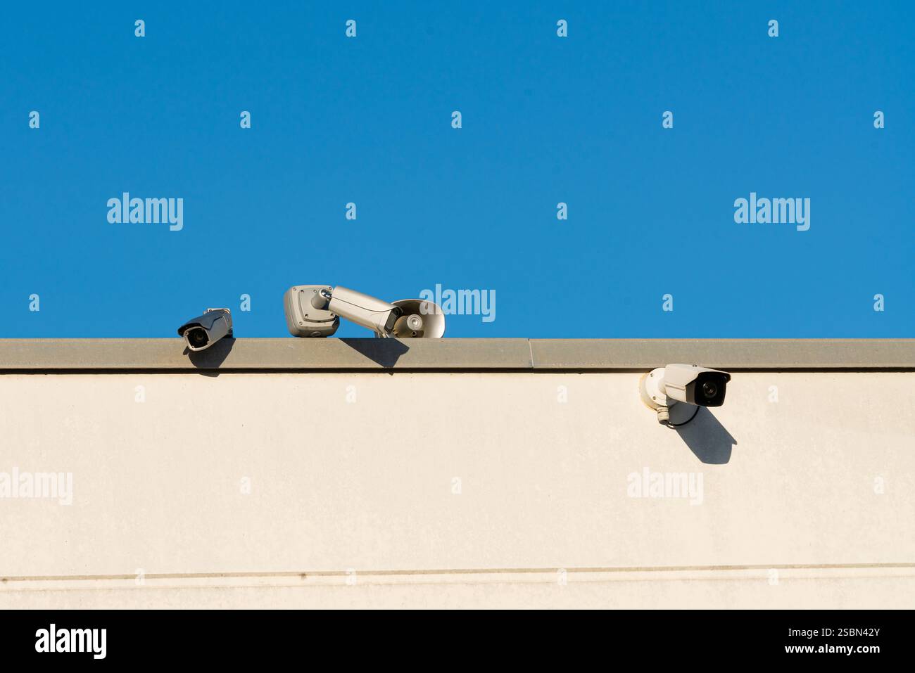 Multiple security cameras are installed on the roof of a building ...