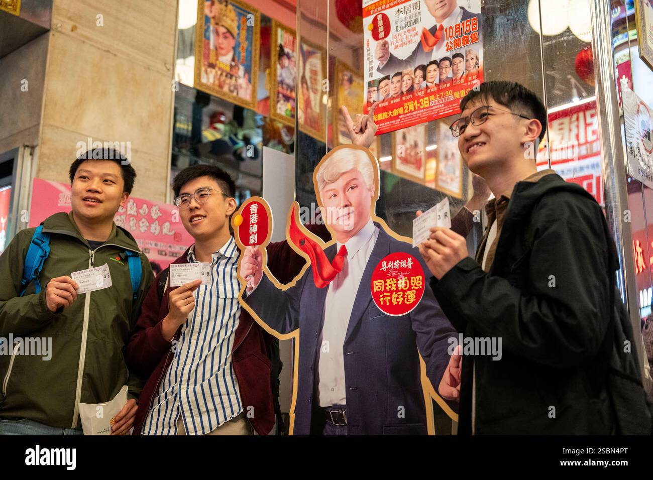 Members of the audience take photographs with a cutout of an actor ...