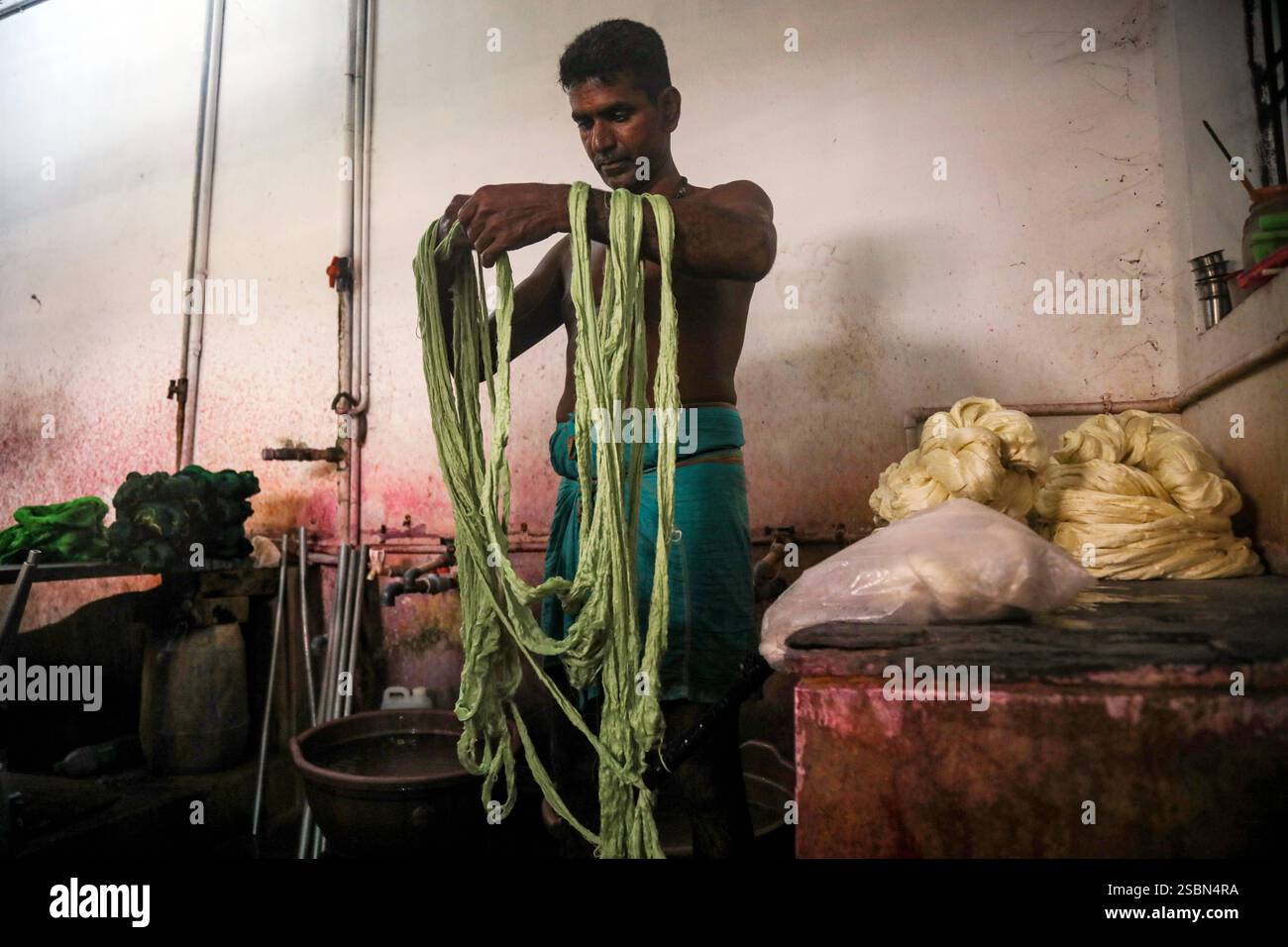 Kanchipuram Sari of India A worker thoroughly rinses silk threads ...