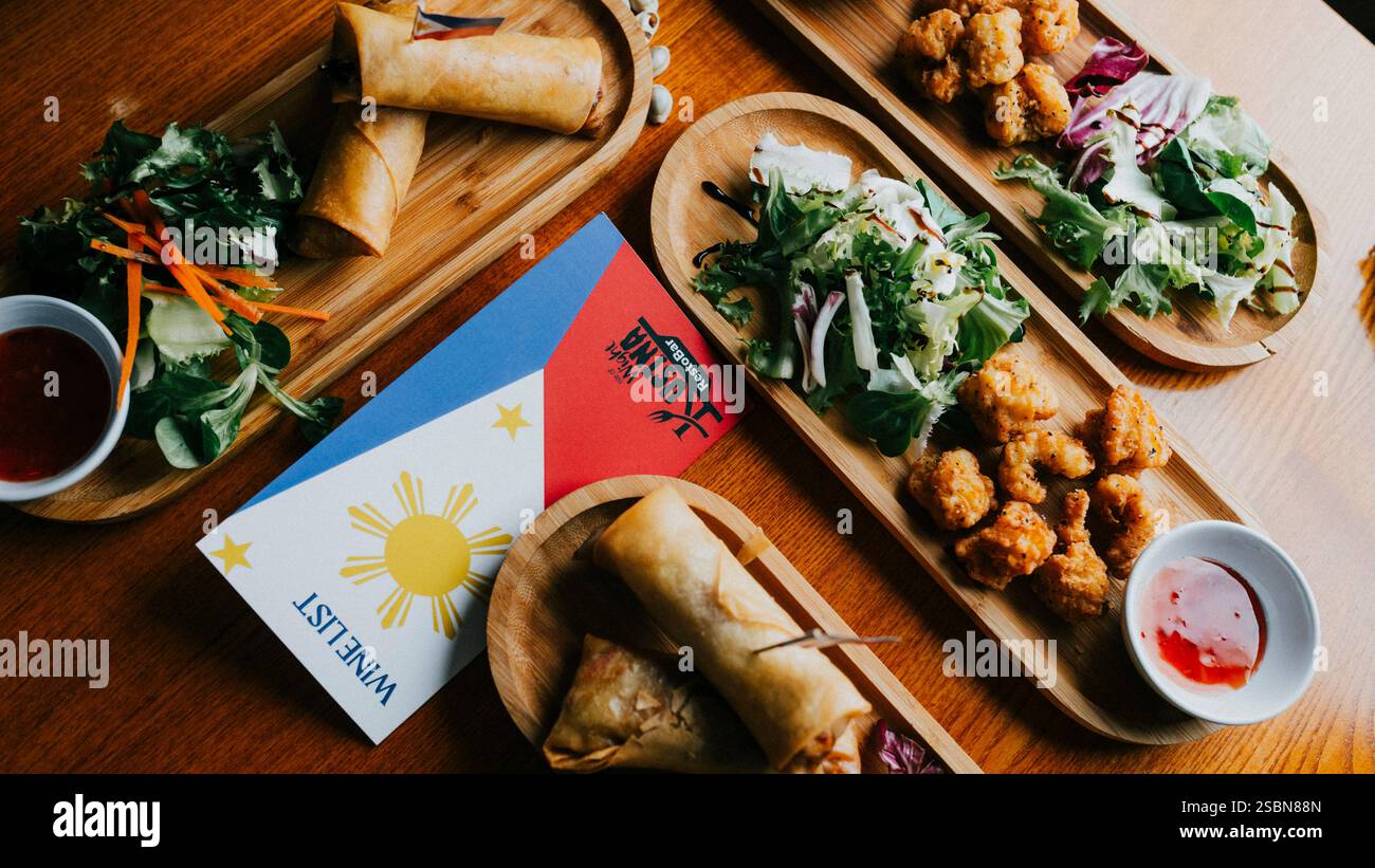 A table with a variety of FILIPENO food and a menu, Scene is casual and ...