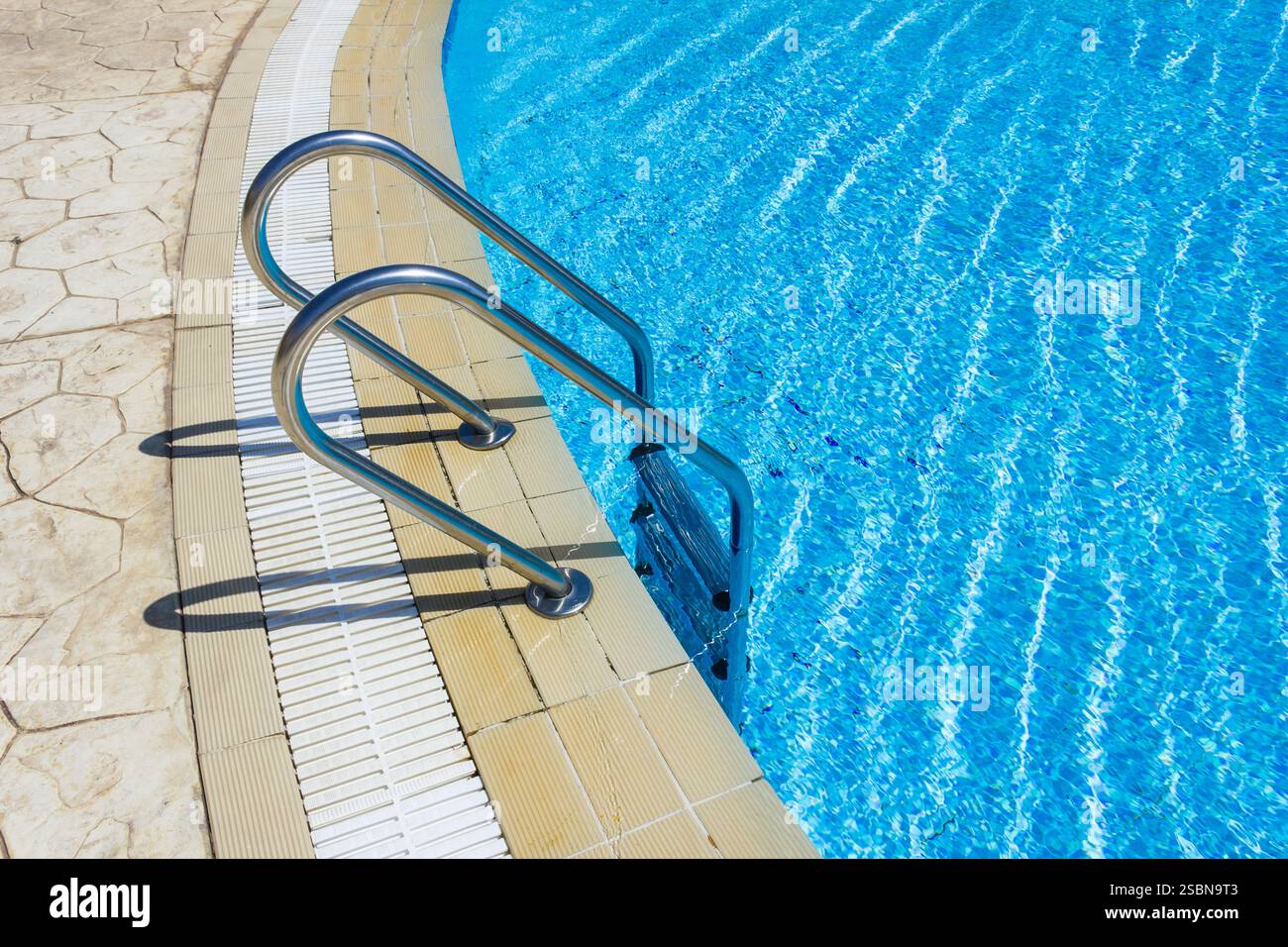 Grab bars ladder in the blue swimming pool Stock Photo - Alamy