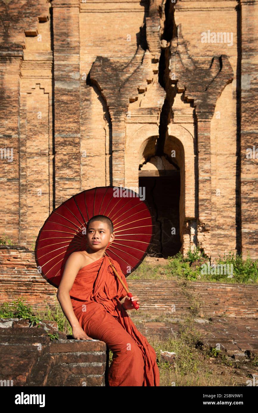 Portrait of a monk holding a parasol at the Mingun Pahtodawgyi or ...