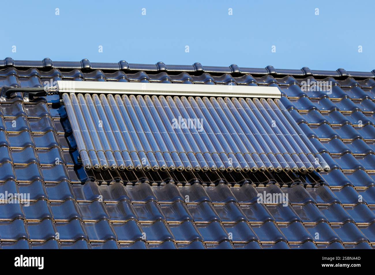 Solar thermal collector with vacuum tubes is mounted on a glossy black ...