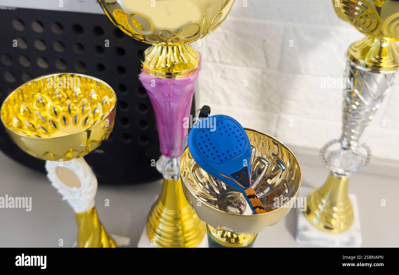 Golden trophy and padel racket. sport achievement, success concept ...