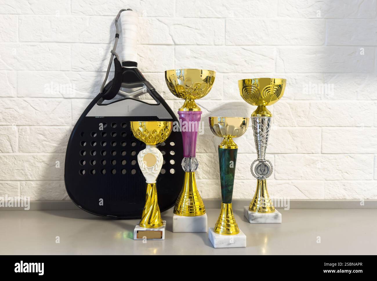 Golden trophy and padel racket. sport achievement, success concept ...