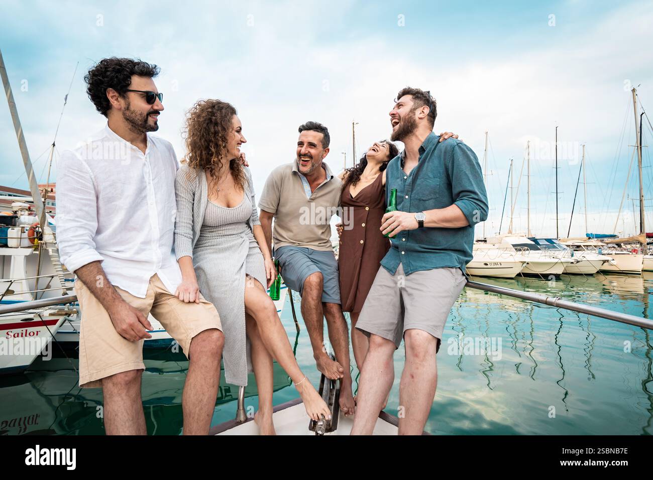 A group of cheerful friends enjoying a fun yacht trip at a marina ...