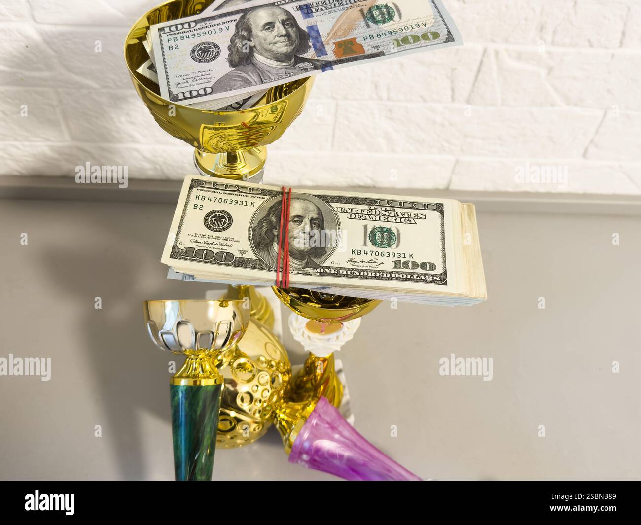Gold Trophy cup on a bunch of cash Stock Photo - Alamy