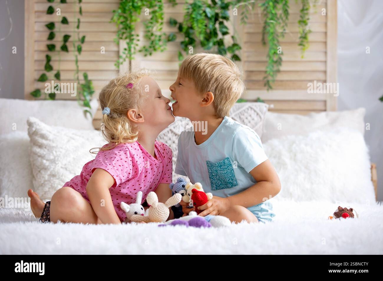 Cute sweet toddler children, tickling feet on the bed, laughing and ...
