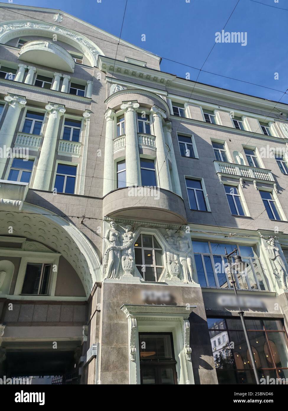 A three-story building with a pale yellow exterior and symmetrical ...