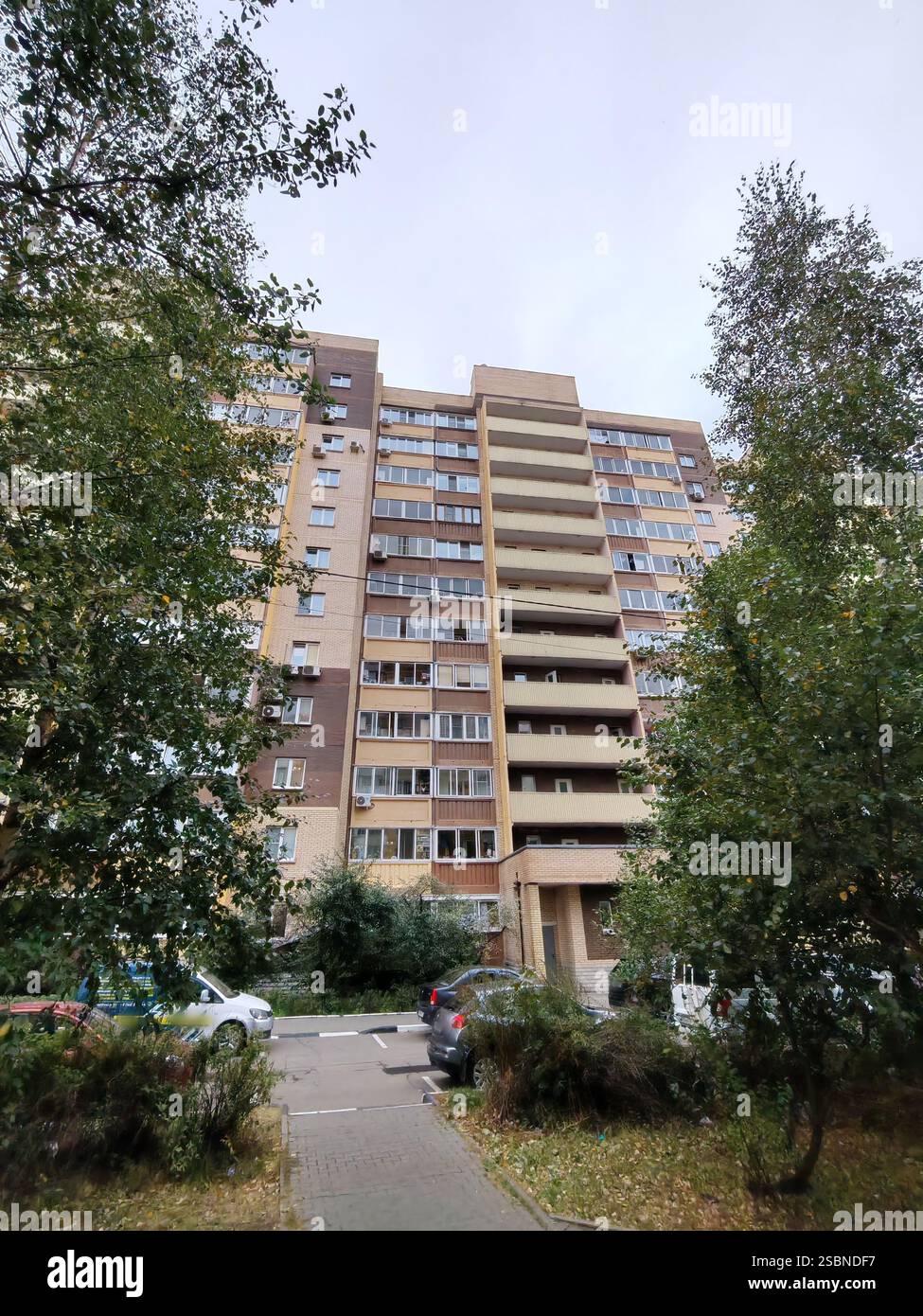 A pastel-colored high-rise residential building with curved balconies ...