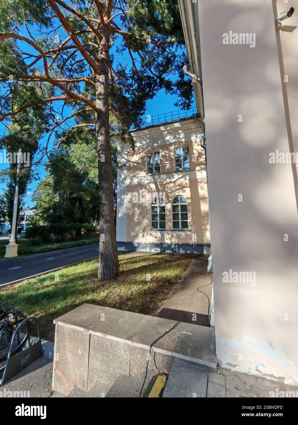 A quiet corner of a beige neoclassical building, surrounded by tall ...