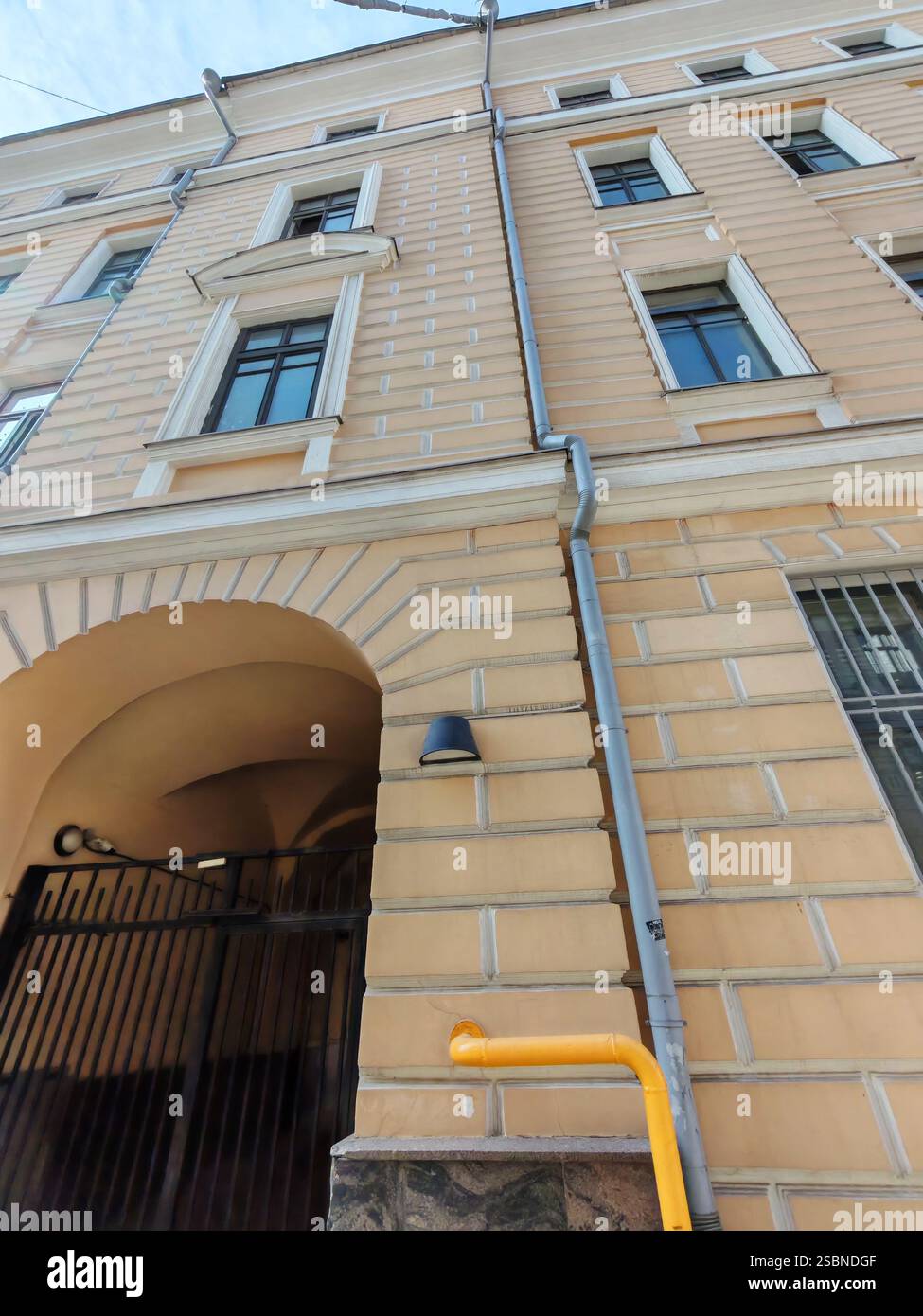 A textured facade of a beige building with symmetrical windows and a ...