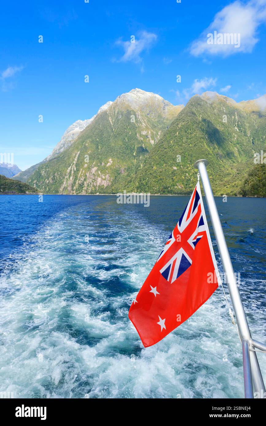 New Zealand, South Island, New Zealand flag flying, Milford Sound Stock ...