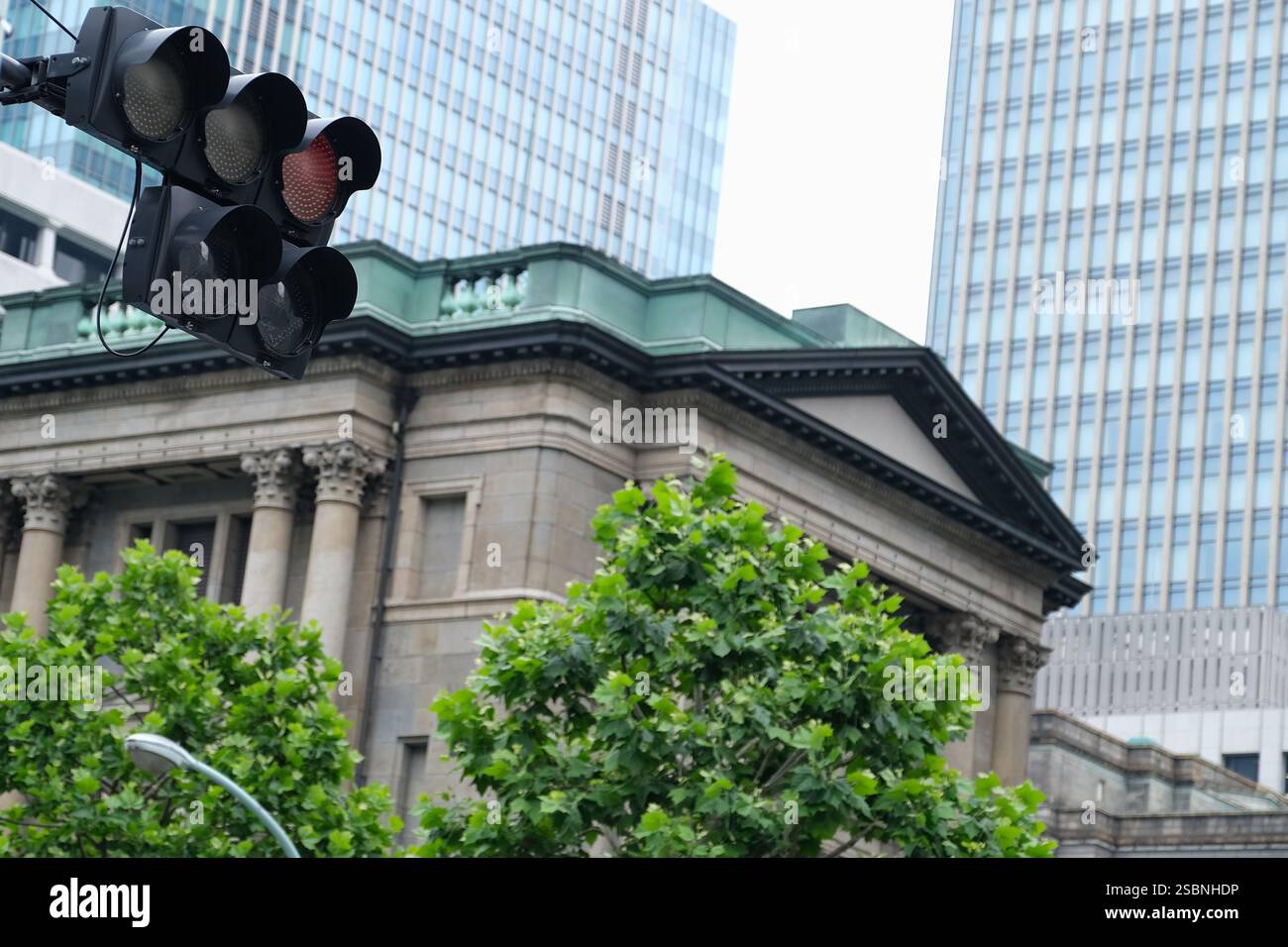The Bank of Japan (BOJ) headquarters stands behind a red street light ...