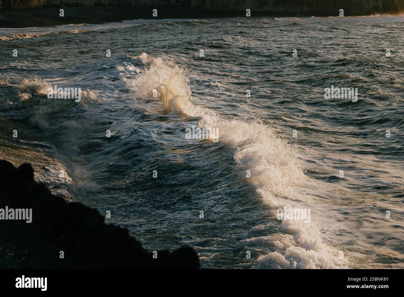 The ocean is calm and the waves are small. The water is a deep blue ...