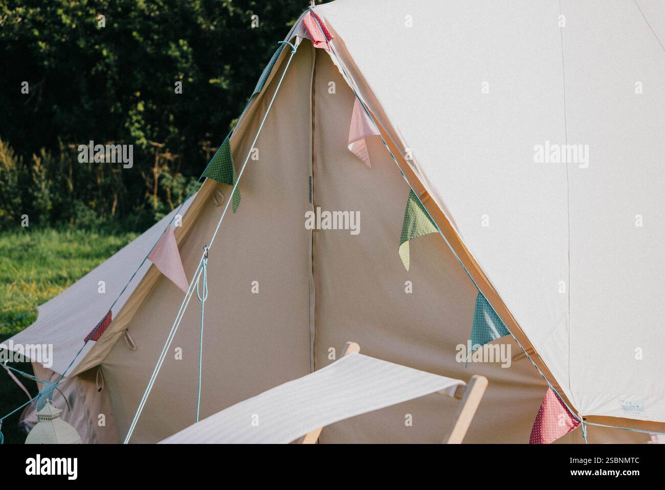 A tent with a white roof and colorful flags hanging from the top. The ...