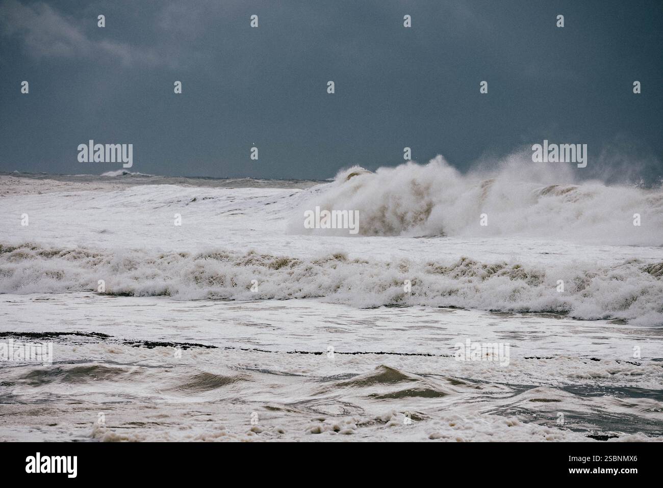 The ocean is rough and the waves are high. The sky is dark and cloudy ...