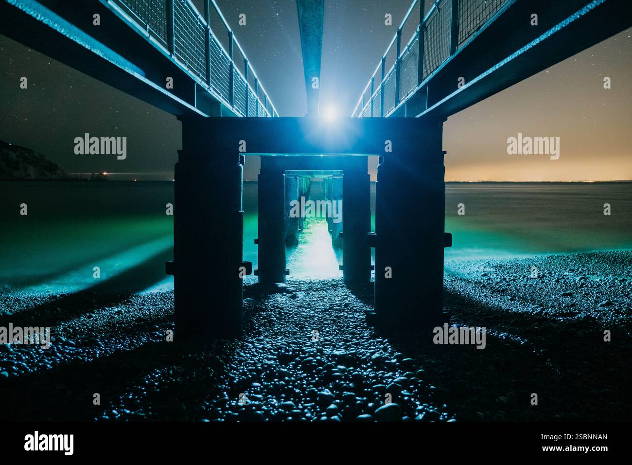 A bridge with a blue light shining on it. The light is shining on the ...