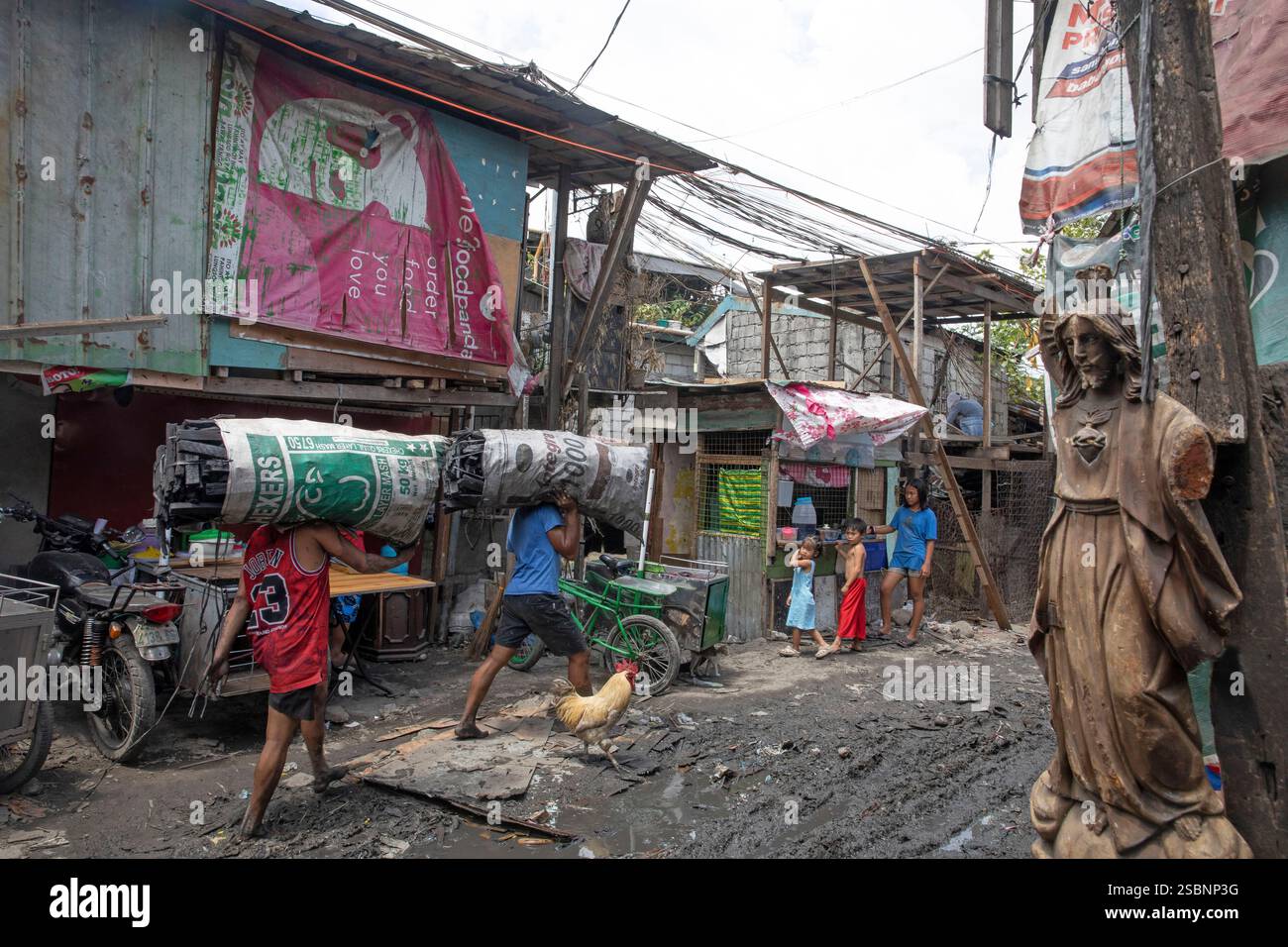 Philippines, Manila, Malabon, coalmen carrying bags of coal in a slum Stock Photo - Alamy