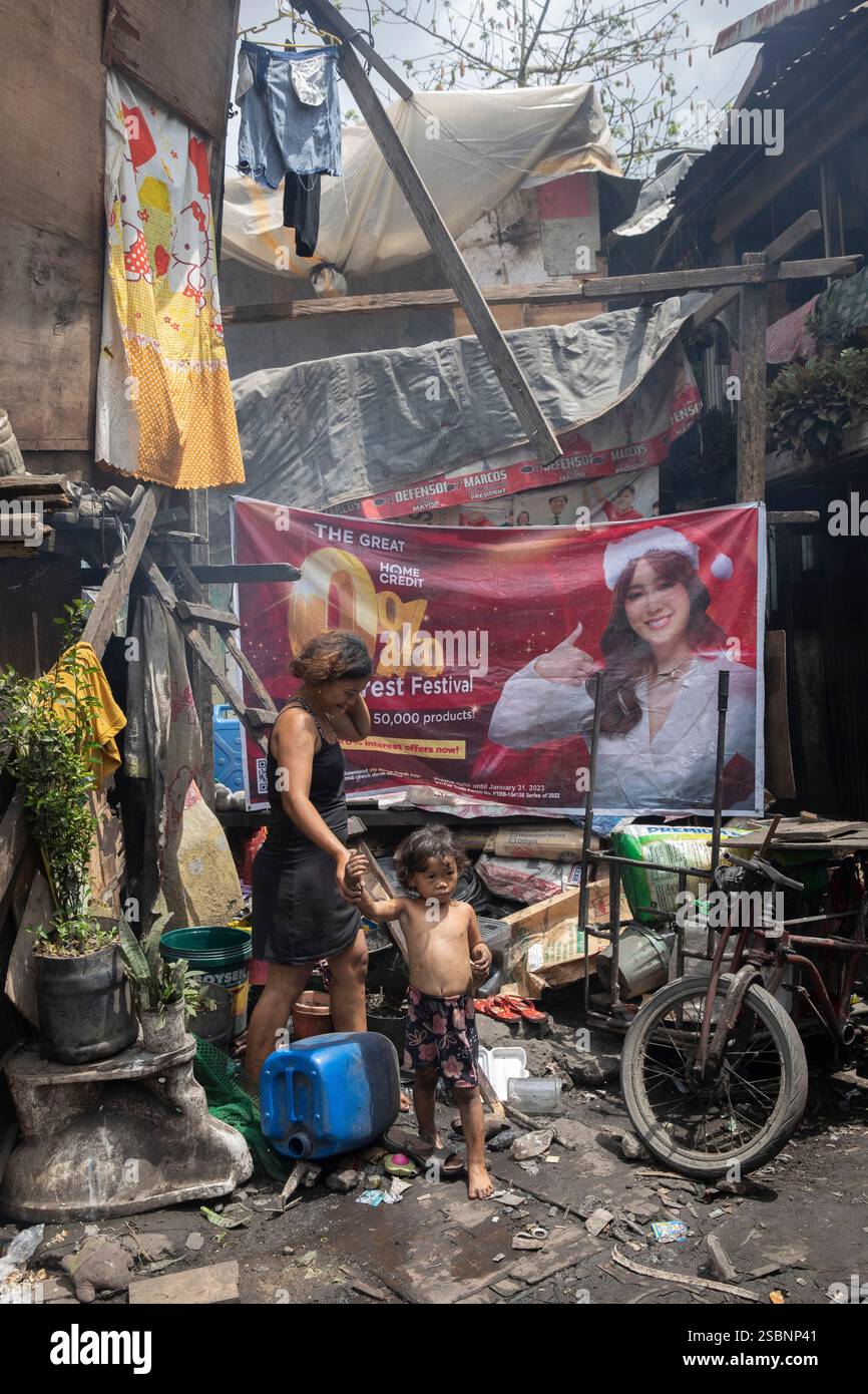 Philippines, Manila, Malabon, woman and her child in fornt of their ...