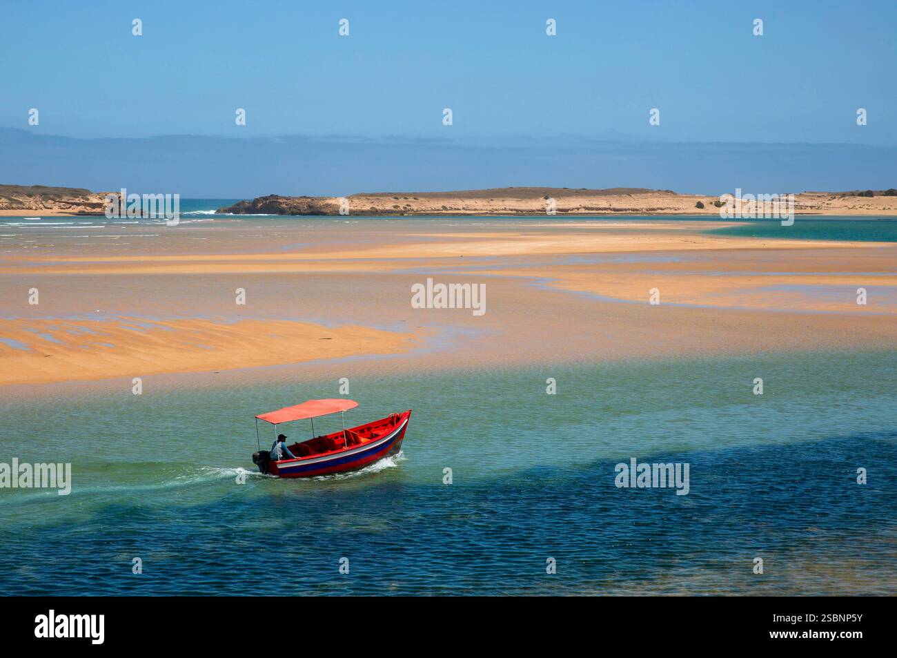 Morocco, Sidi Bennour province, Oualidia, colorful boat in the blue water lagoon, facing ...