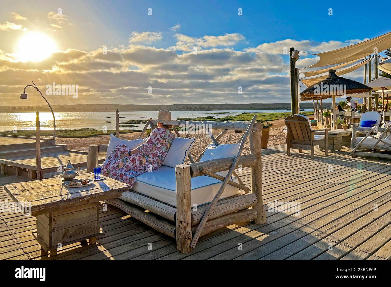 Morocco, Sidi Bennour province, Oualidia, woman on a bench on the ...