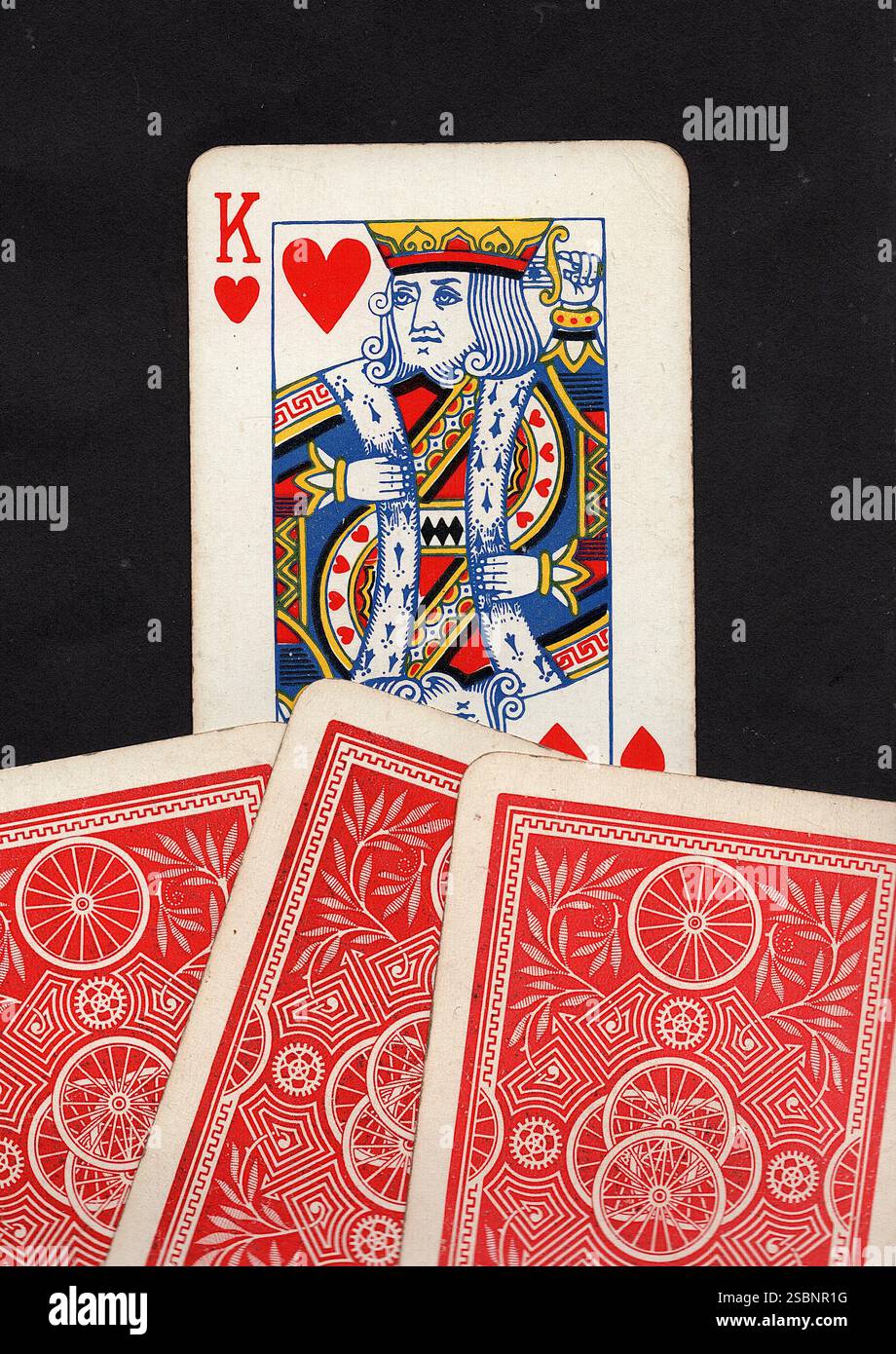 A montage of vintage playing card backs with the king of hearts ...