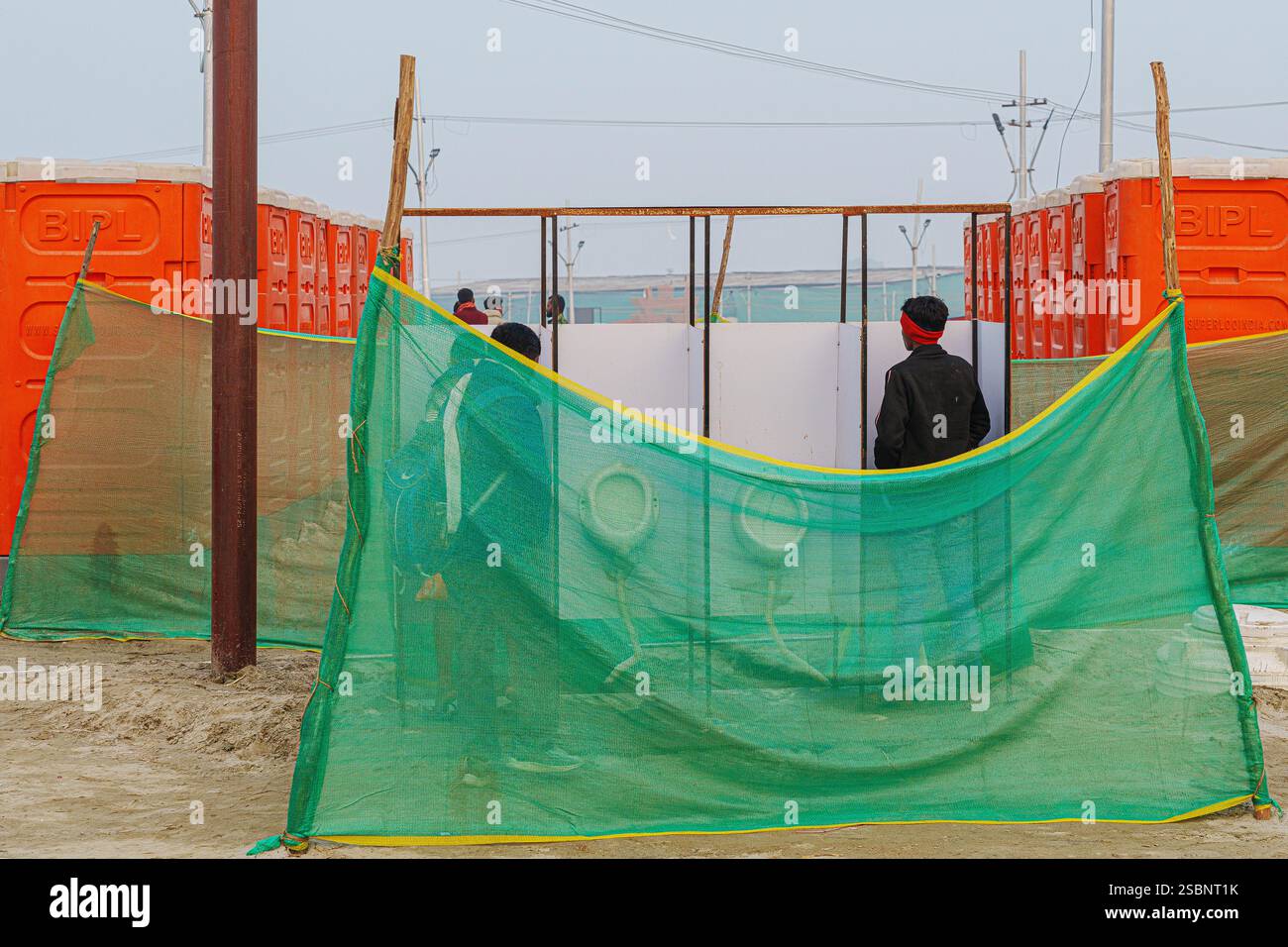Two men use the urinals while another enters, capturing a common yet ...