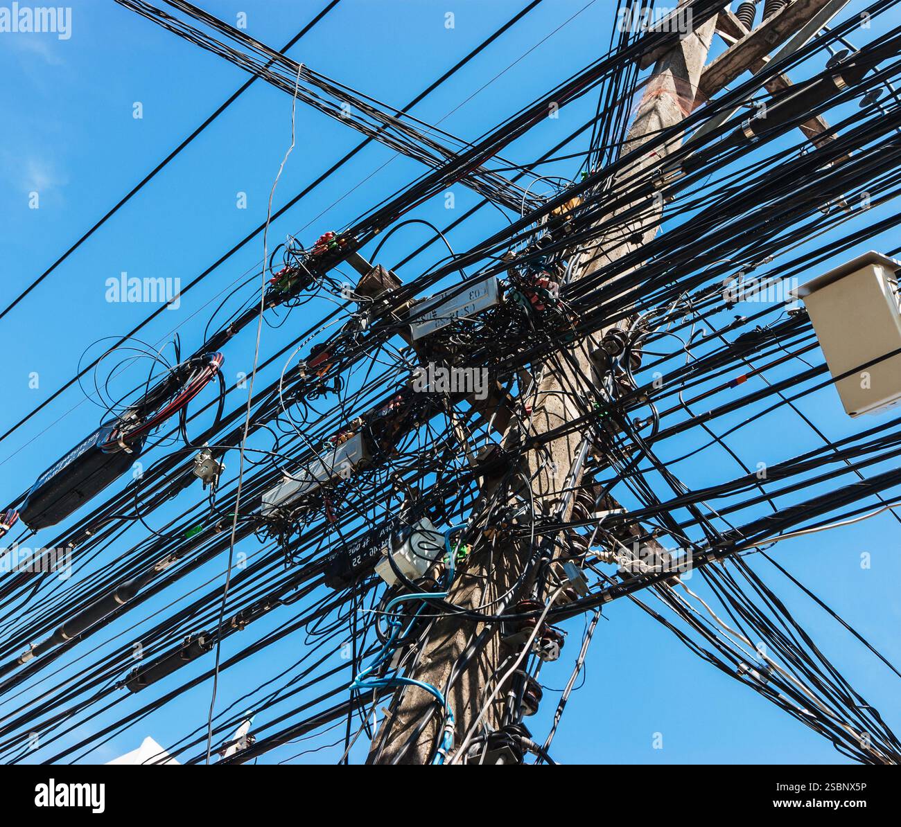 Intertwining of many electrical wires on poles Stock Photo - Alamy