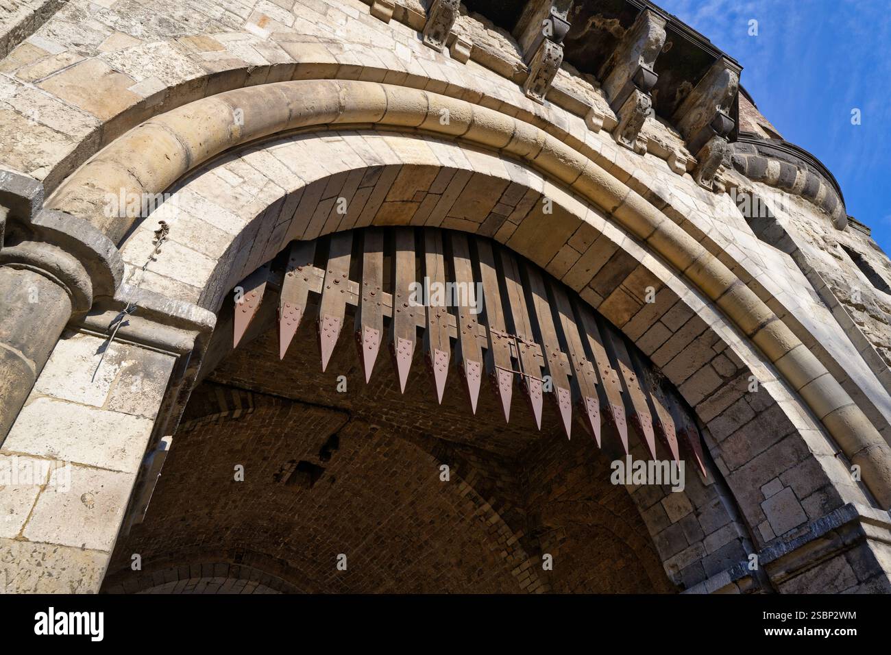 raised wooden portcullis with metal spikes at the gate castle of a ...