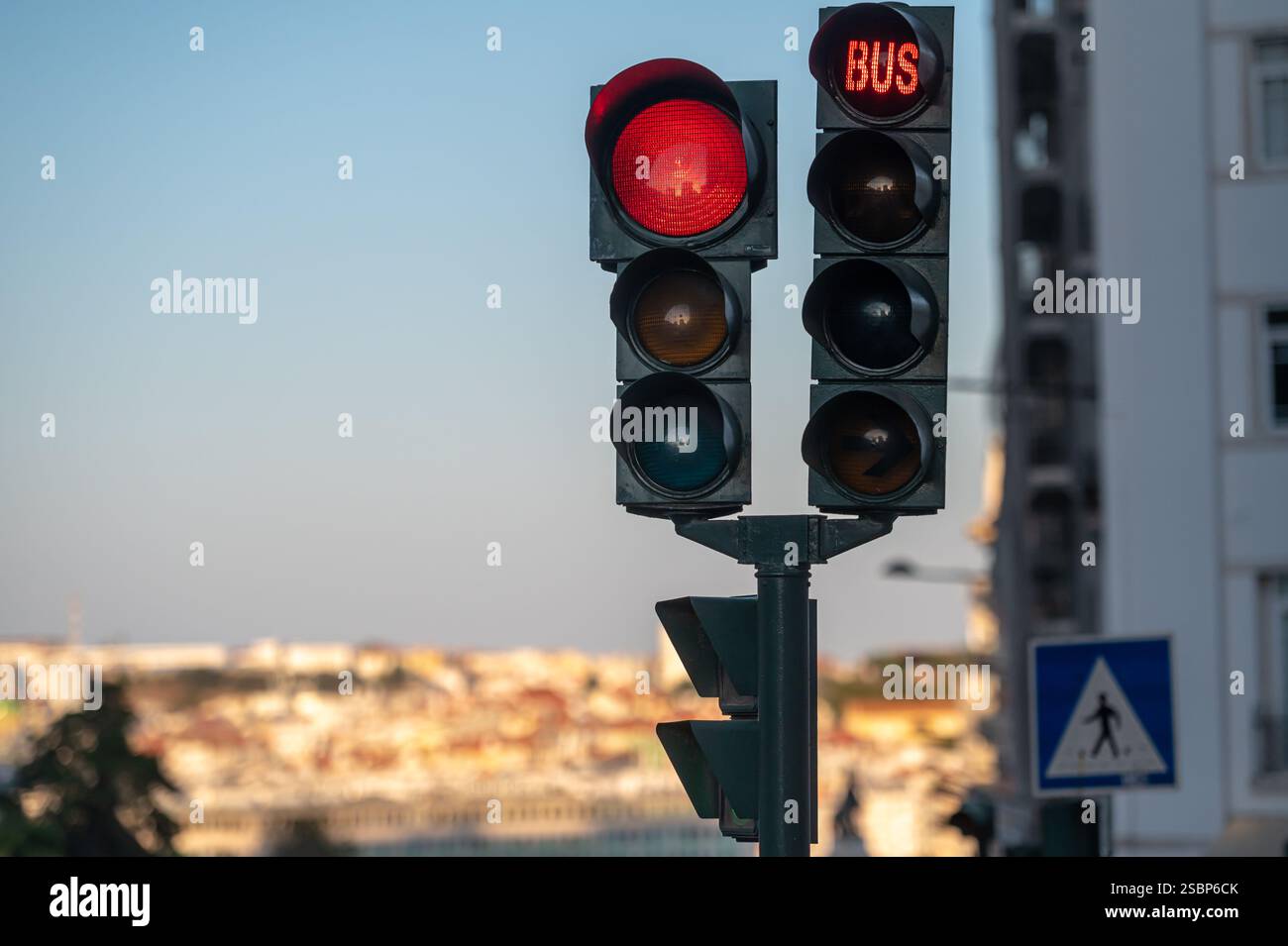 A red traffic signal displays a bus indicator at a busy city ...